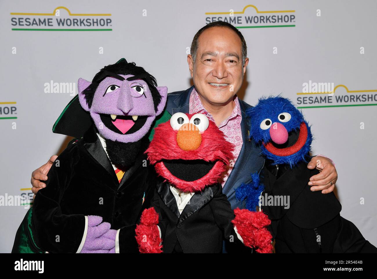 Actor Alan Muraoka, center, poses with Count von Count, Elmo and Grover ...