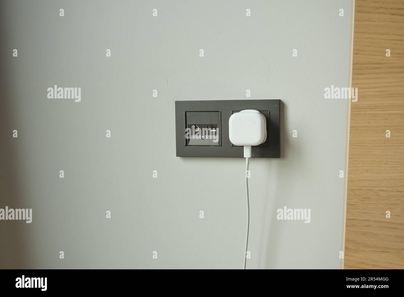 white color power cord cable plugged into wall Stock Photo - Alamy