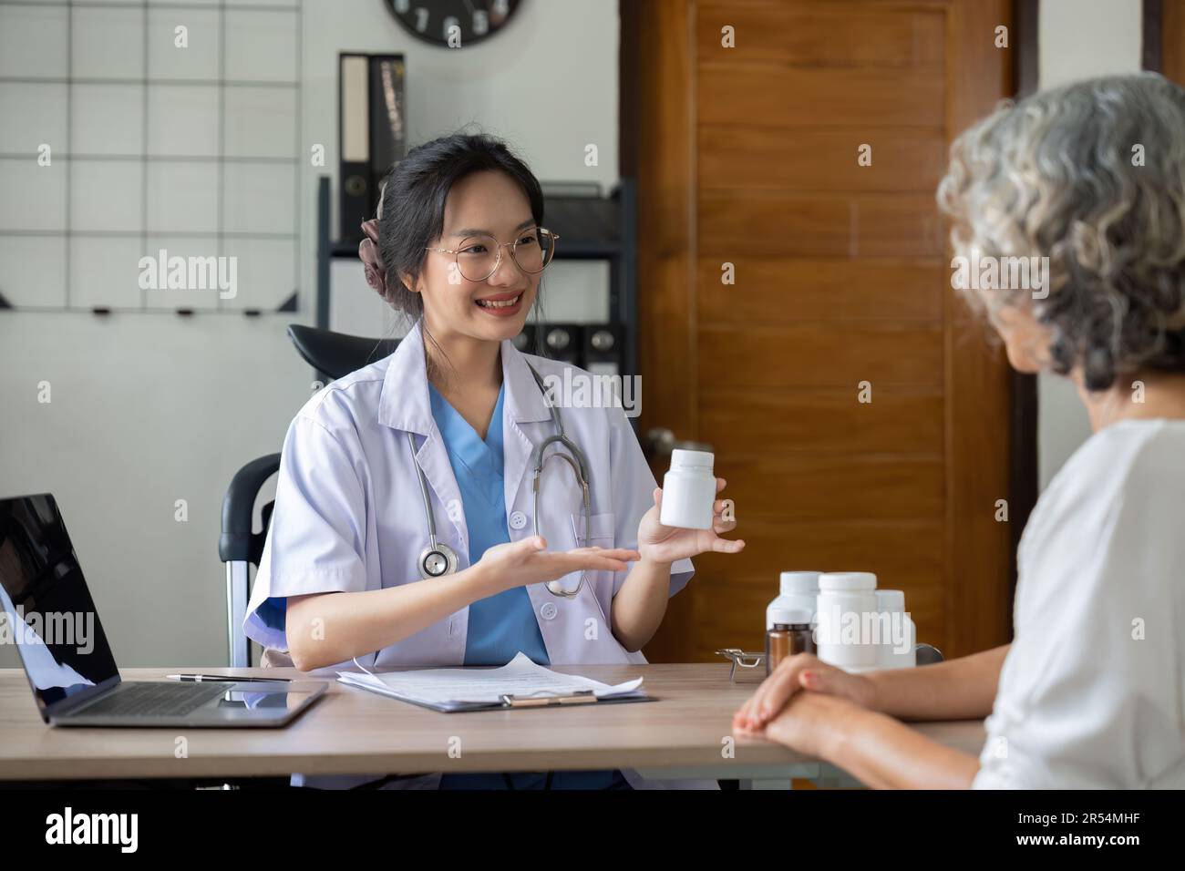 Doctor or physician writing diagnosis and giving a medical prescription ...