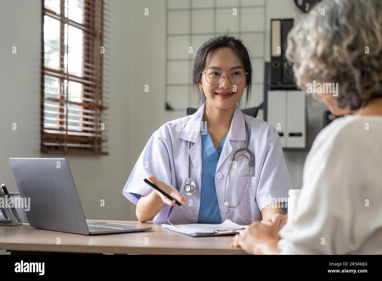 Doctor or physician writing diagnosis and giving a medical prescription ...