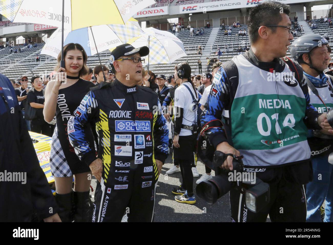 Toyota Chairman Akio Toyoda, center, stands next to the racing car ...