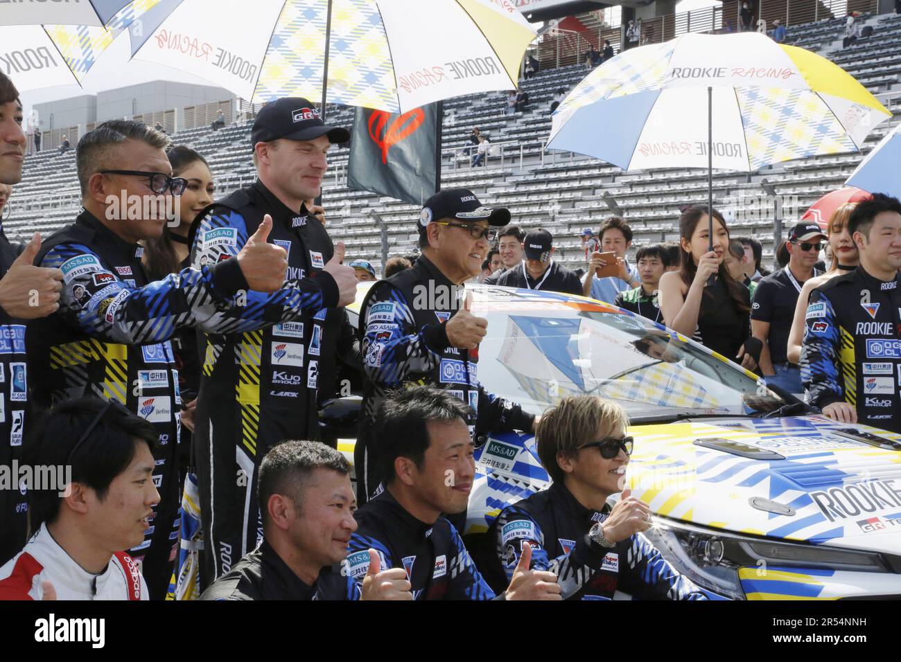 Toyota Chairman Akio Toyoda, center, stands next to the racing car ...