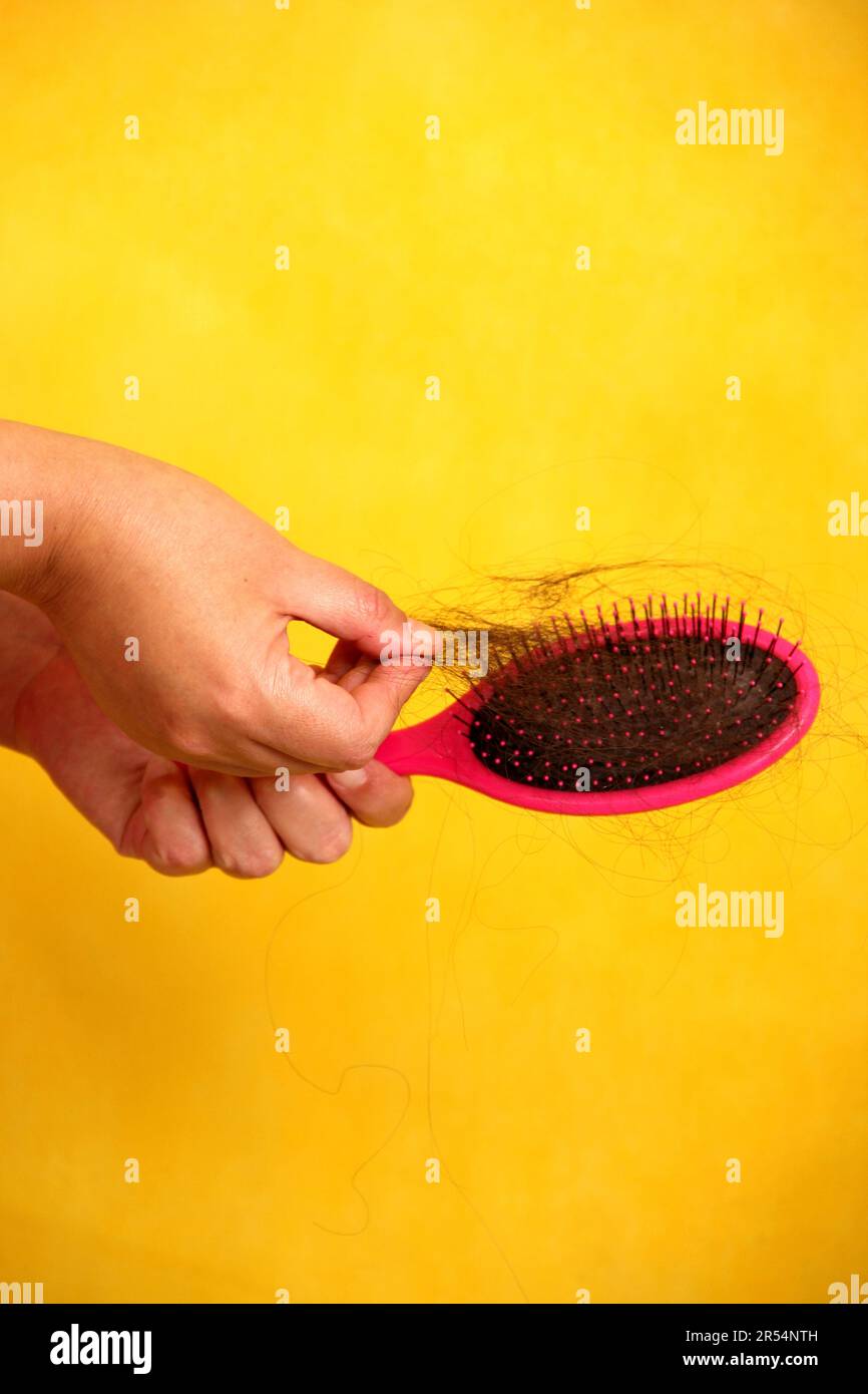 Adult Latina woman suffers from hair loss when brushing it, a symptom ...