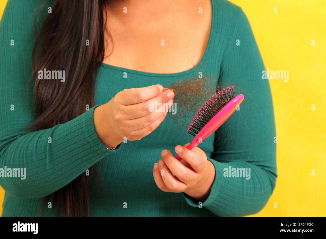 Adult Latina woman suffers from hair loss when brushing it, a symptom ...