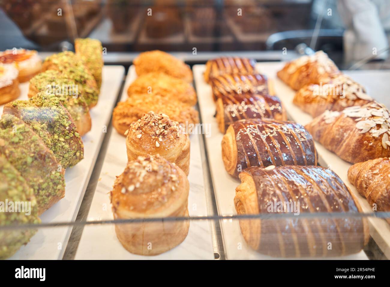 A variety of fresh pastries in the bakery window. almond croissant is ...