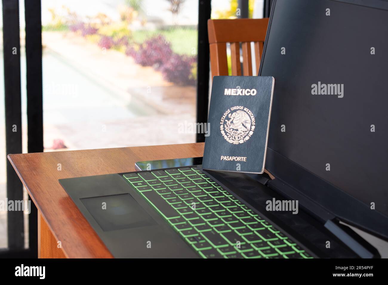 Mexican passport on black laptop computer. Out of focus background of a ...