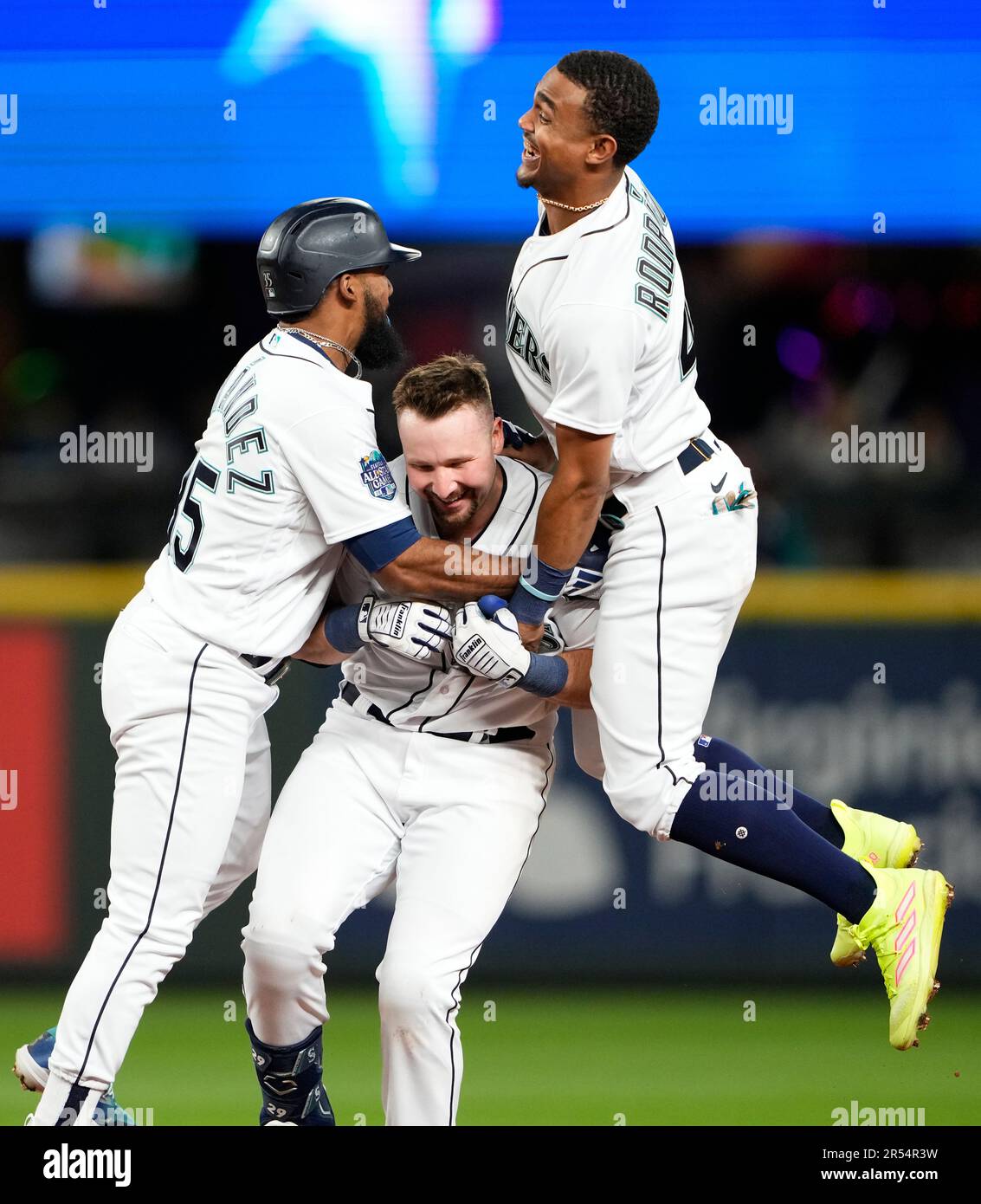 Seattle Mariners' Cal Raleigh, center, is greeted by Teoscar Hernandez, left, and Julio ...
