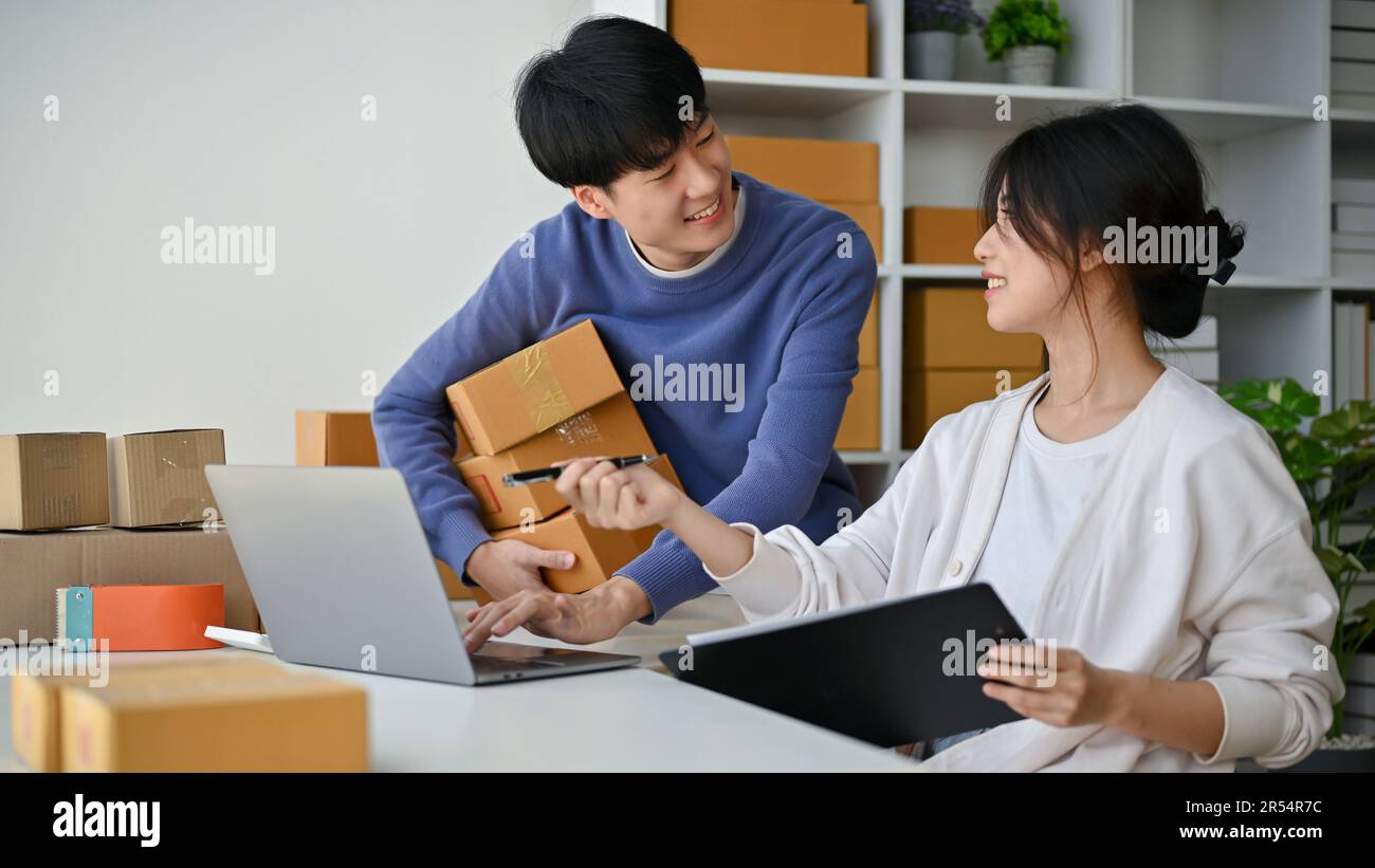 A lovely and happy young Asian couple is talking and showing affection while working and ...