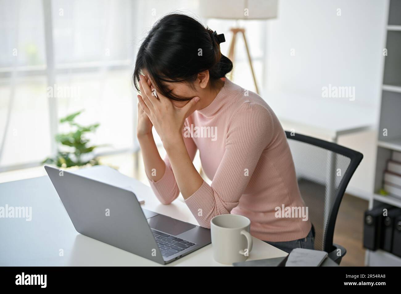 Stressed and frustrated Asian businesswoman covering her face and ...