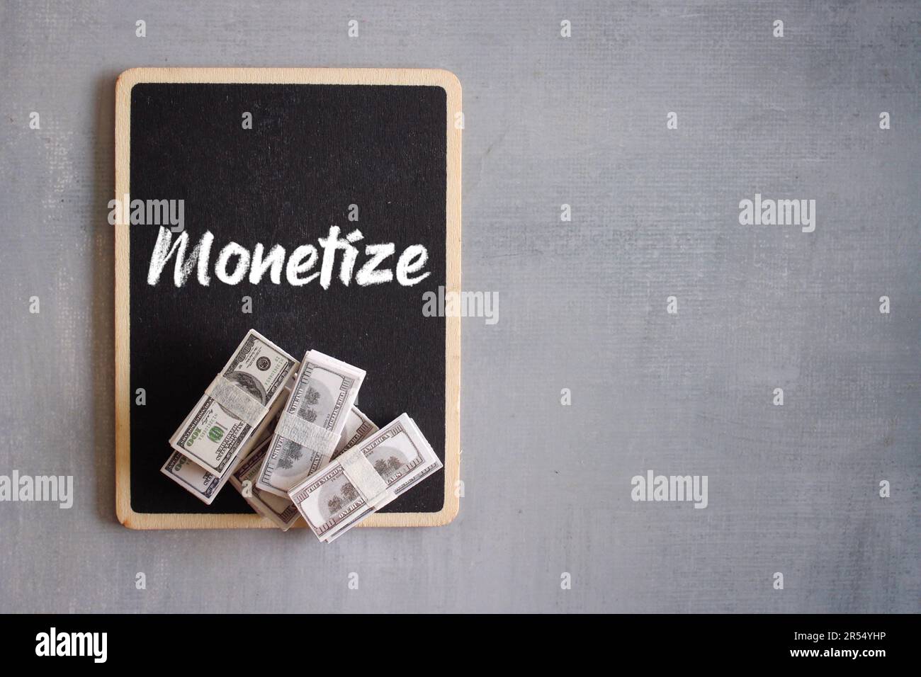 Top view stack of money and text MONETIZE with copy space for text ...