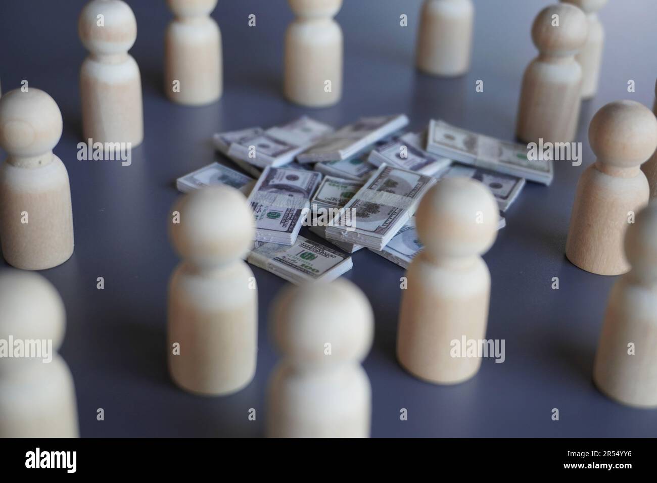 Group of wooden dolls and stack of money. Finance, donation, investor ...