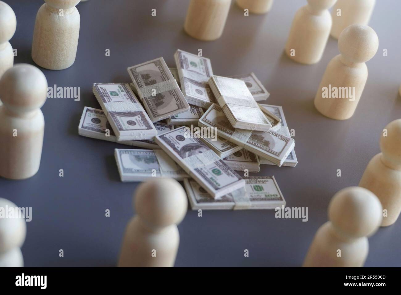 Group of wooden dolls and stack of money. Finance, donation, investor ...