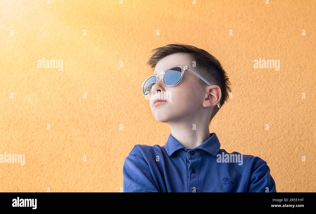 Portrait of a surprised cute boy in sunglasses. A child with an ...