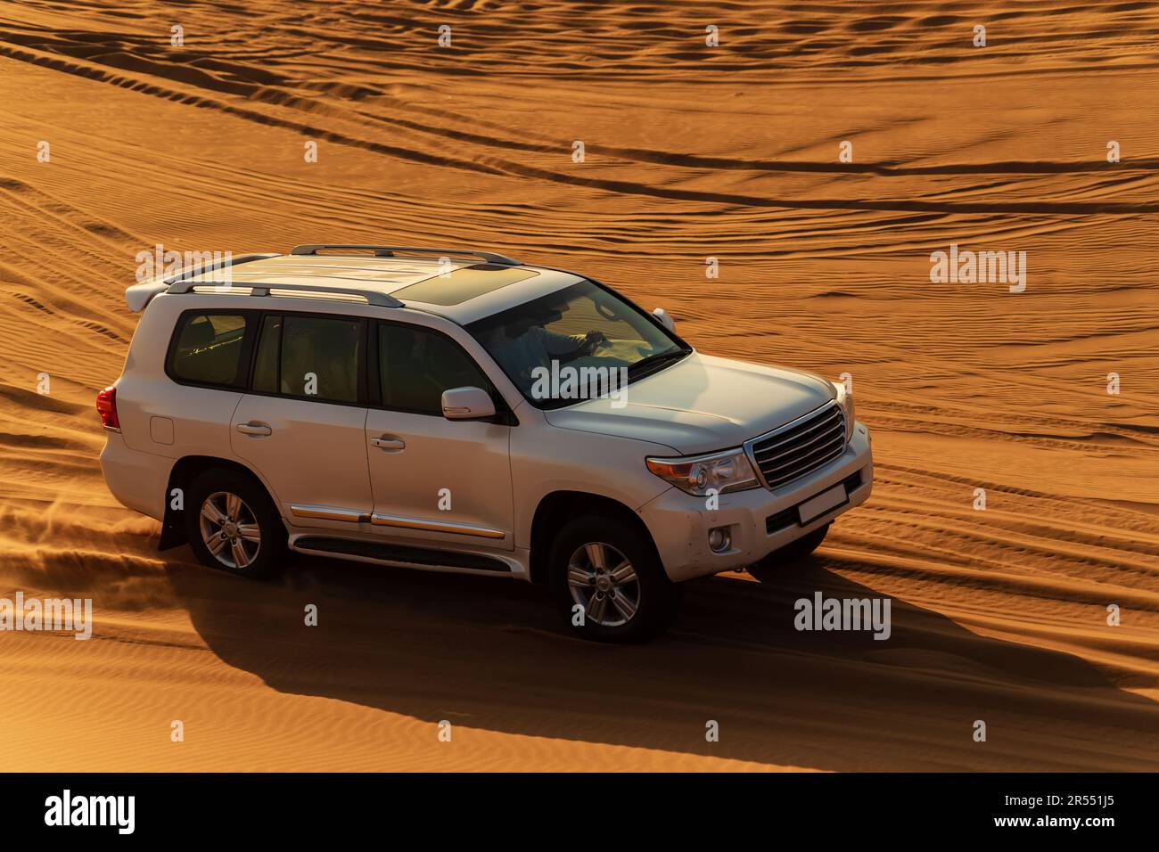 White car driving in Rub al Khali Desert at the Empty Quarter, in Abu ...