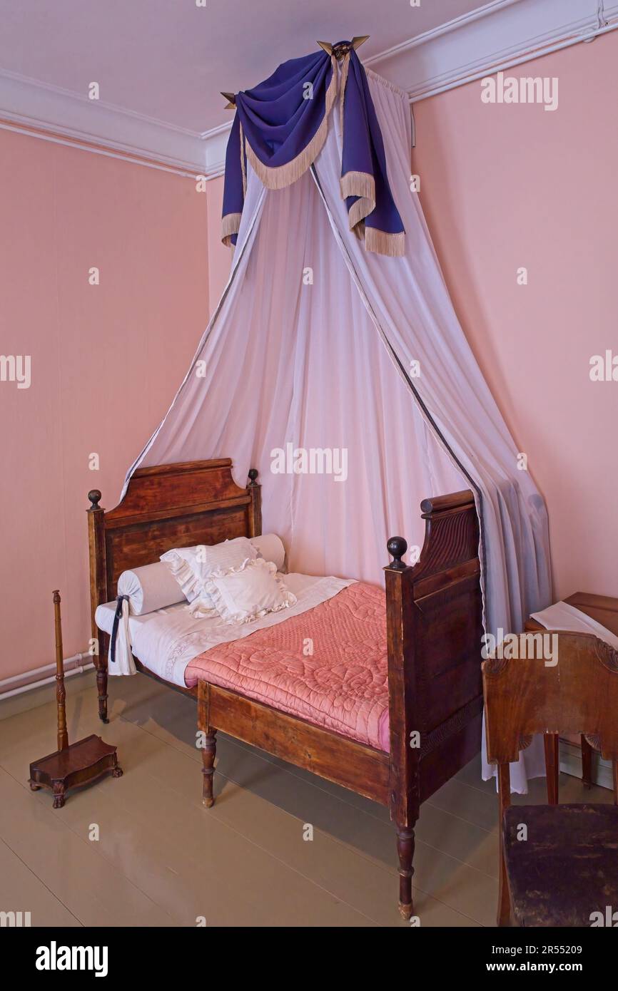 Old fashioned wood bed with pink walls Stock Photo - Alamy