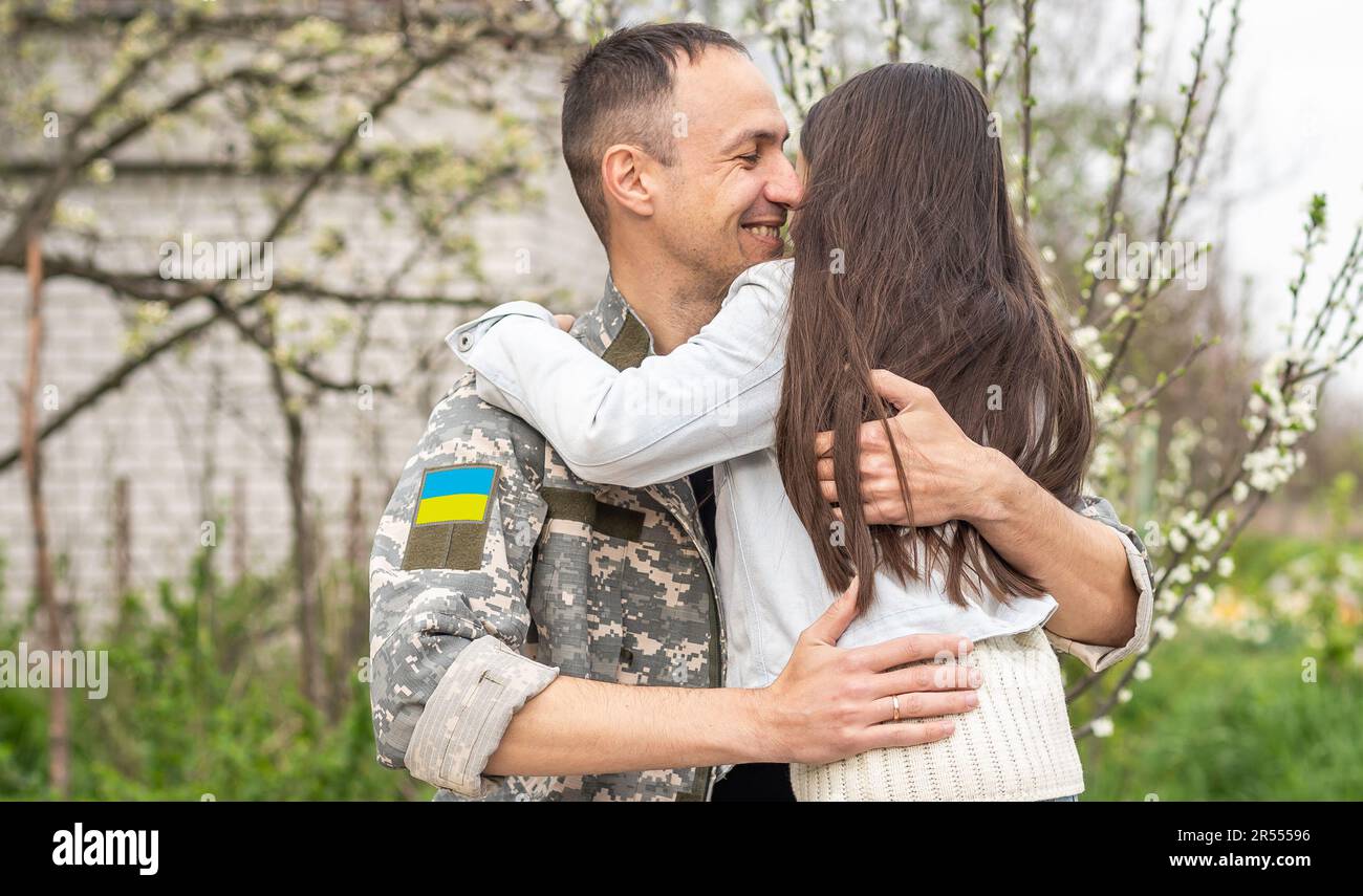 Soldier in Ukrainian military uniform hugging his daughter. Family ...