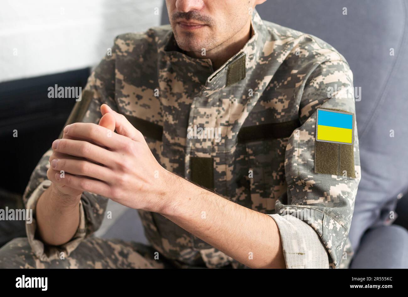 A Ukrainian military man holds the national flag in his hands as a ...