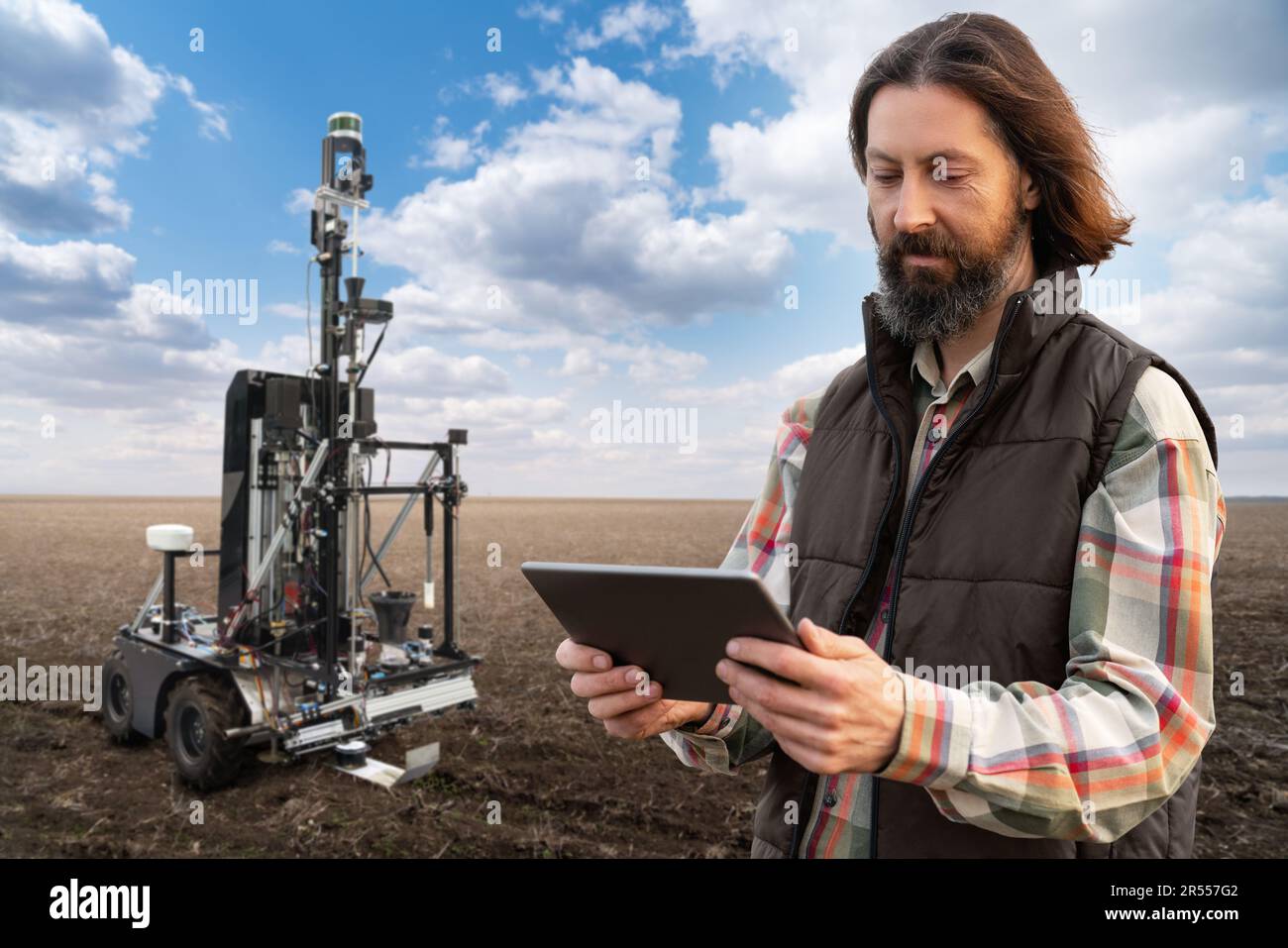 Farmer controls autonomous robot for measuring soil quality in an ...