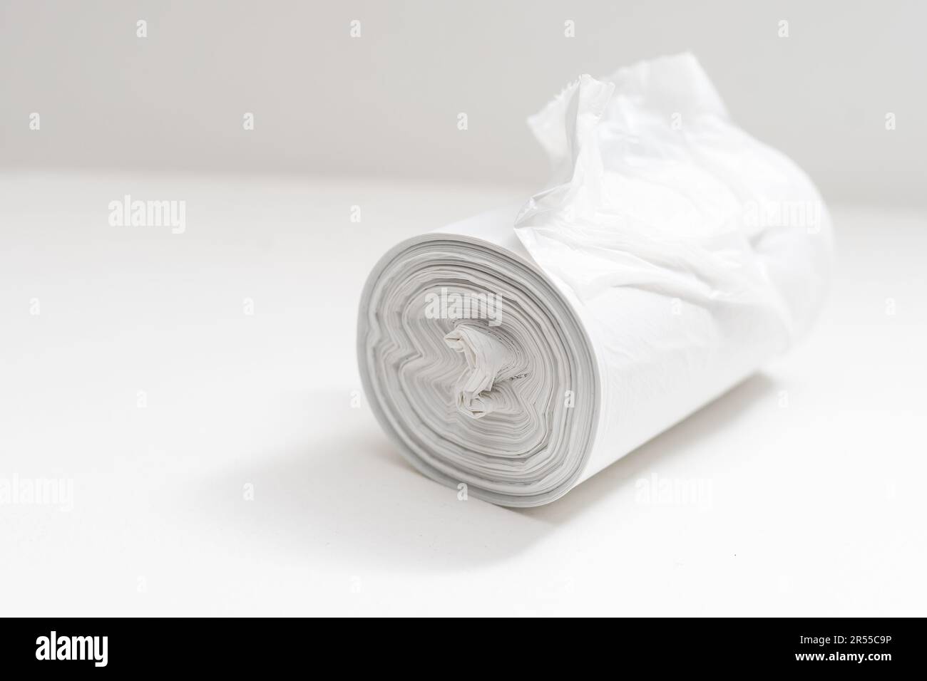 White plastic polyethylene trash bag roll isolated over the white ...