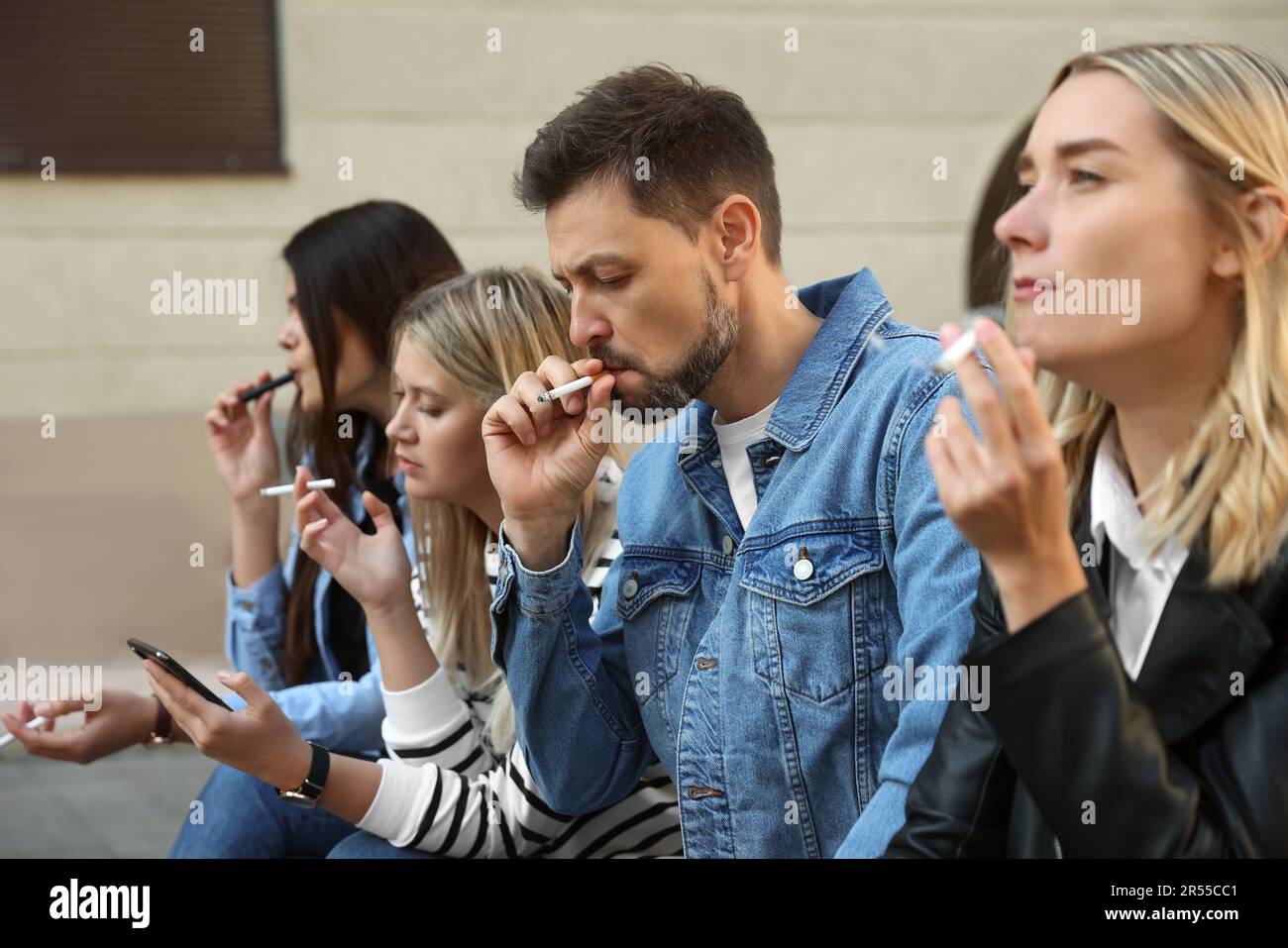People smoking cigarettes at public place outdoors Stock Photo - Alamy