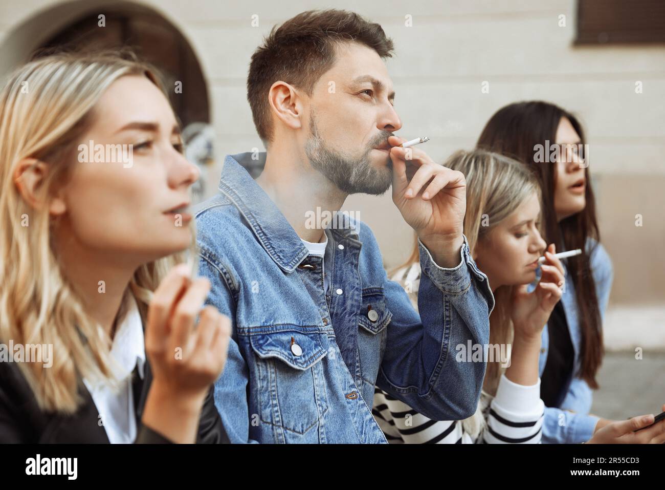 People smoking cigarettes at public place outdoors Stock Photo - Alamy