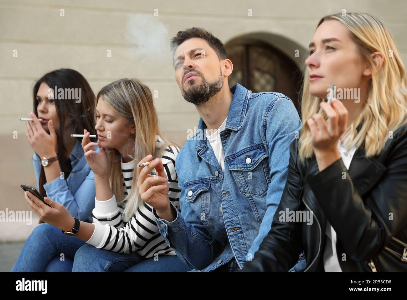 People smoking cigarettes at public place outdoors Stock Photo - Alamy