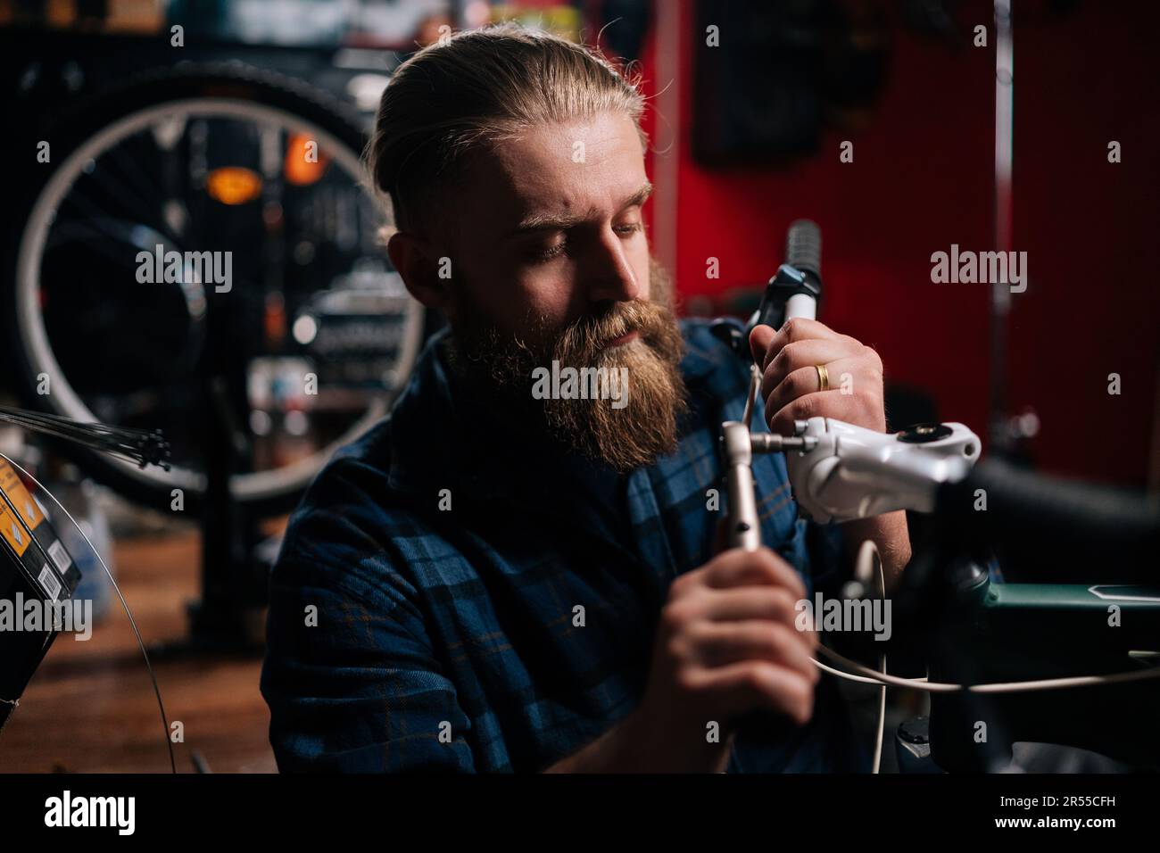Closeup portrait of concentrated cycling mechanic male checking and ...