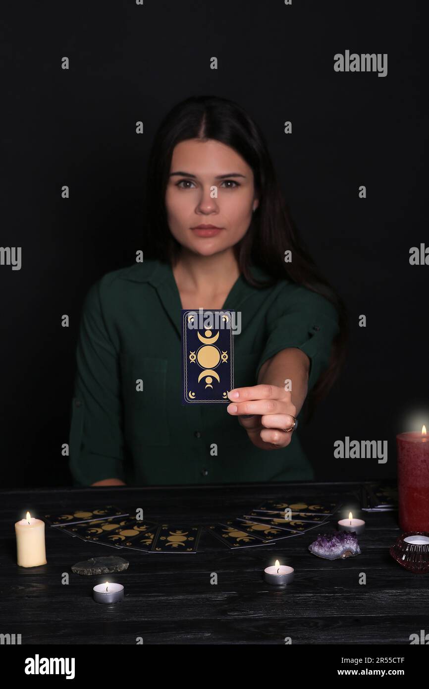 Soothsayer predicting future at table against black background, closeup ...