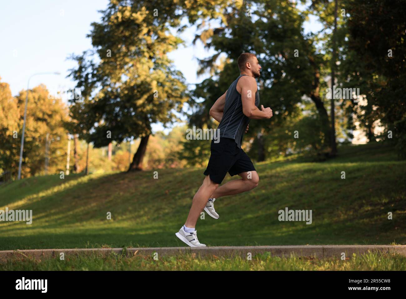 Attractive man jogging along path hi-res stock photography and images ...