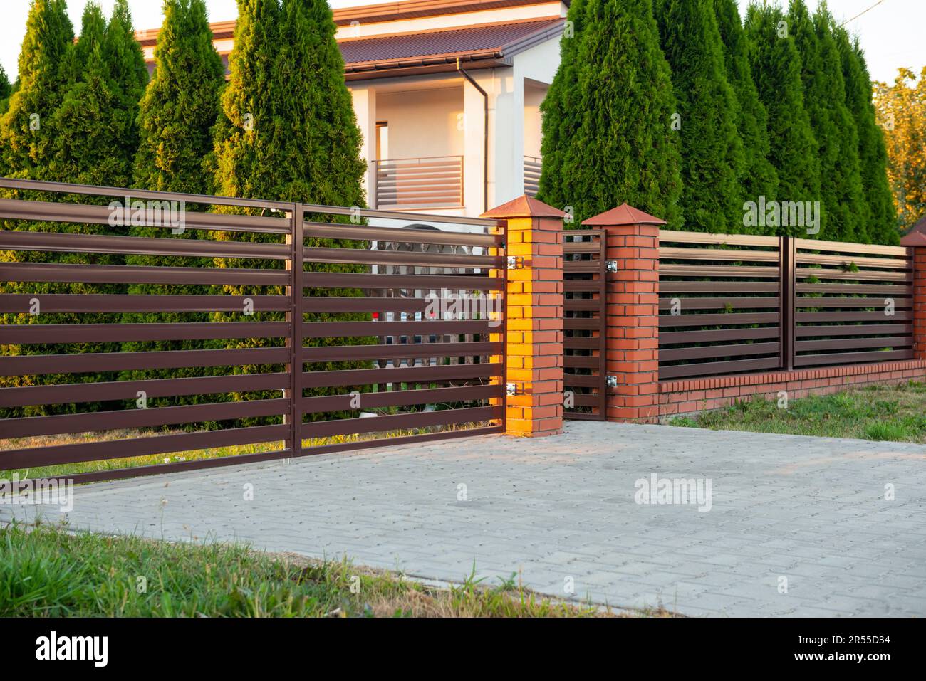 Beautiful brick fence with iron panels outdoors Stock Photo - Alamy
