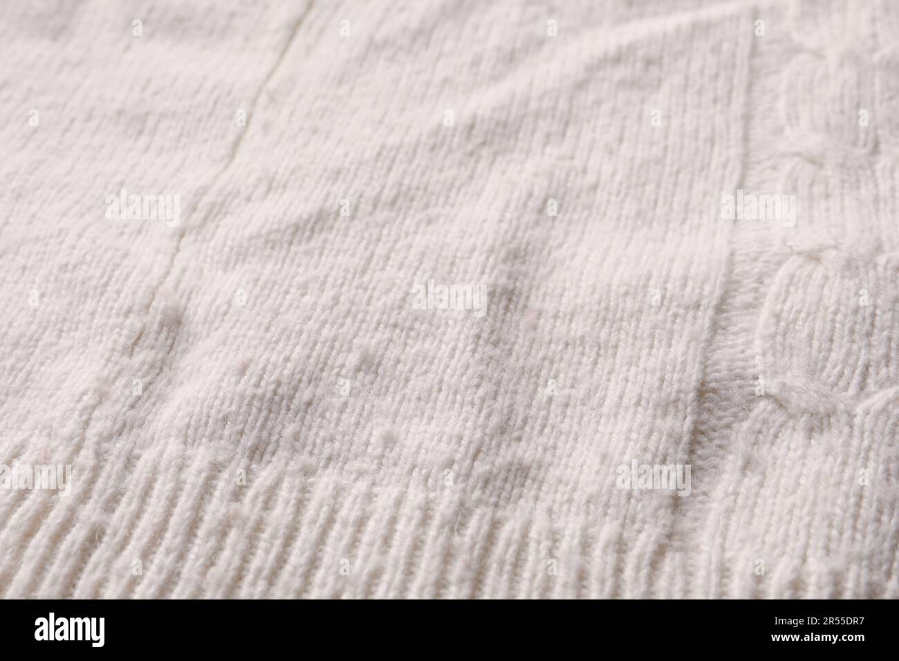 Knitted cloth with lint as background, closeup. Before using of fabric ...