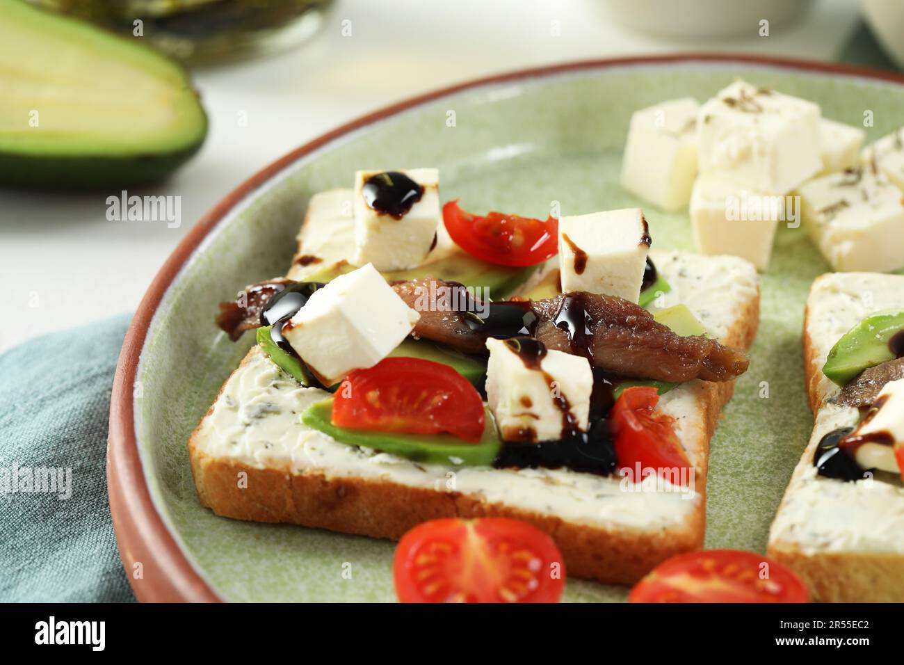 Delicious sandwiches with anchovies, cheese and tomato on white table ...