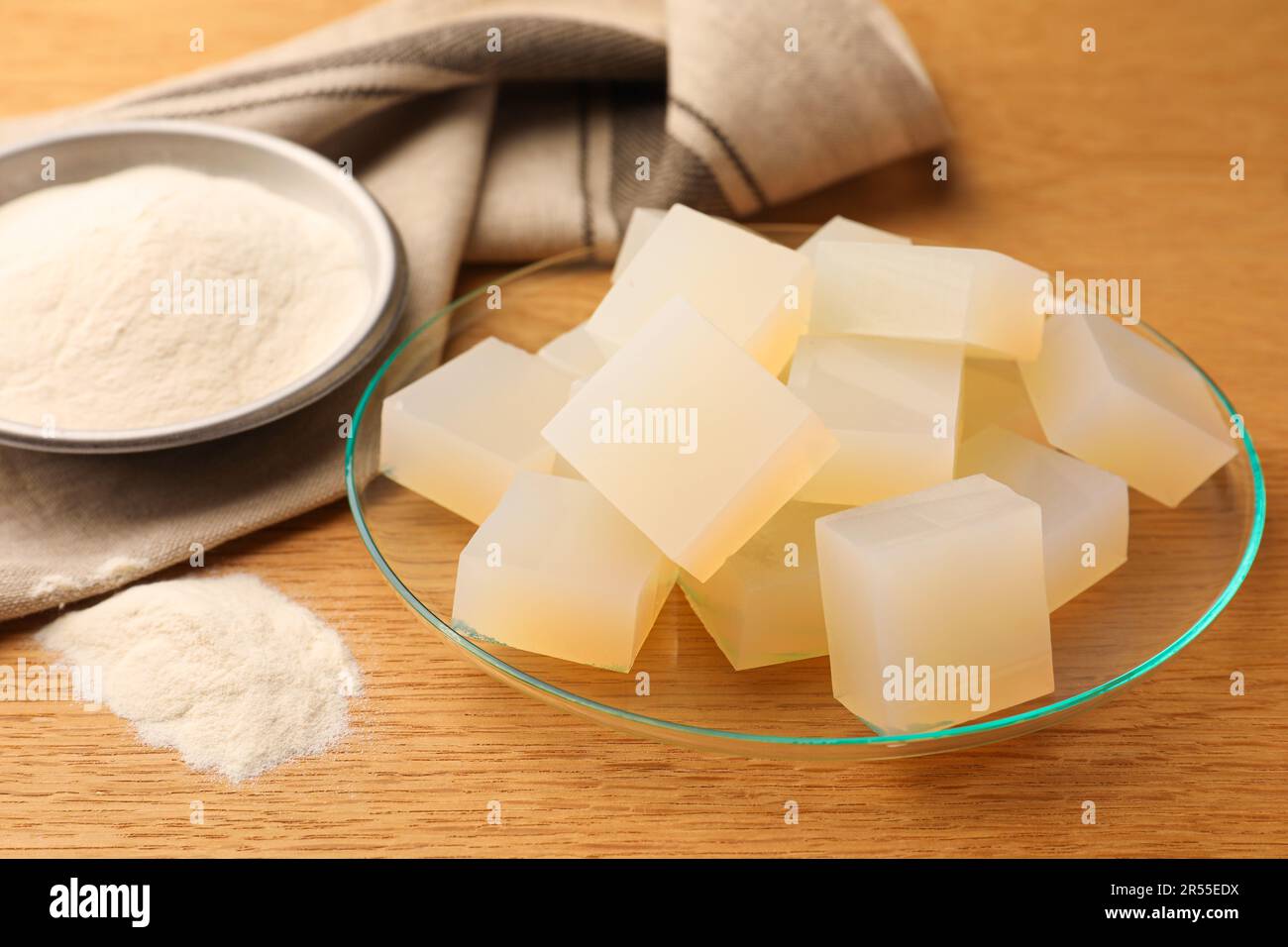 Agar-agar jelly cubes and powder on wooden table, closeup Stock Photo ...