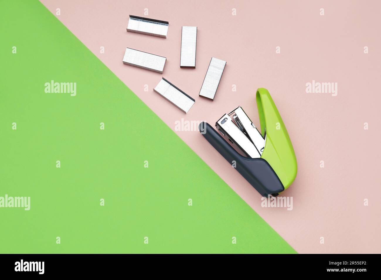 New bright stapler with staples on color background, fat lay. Space for ...