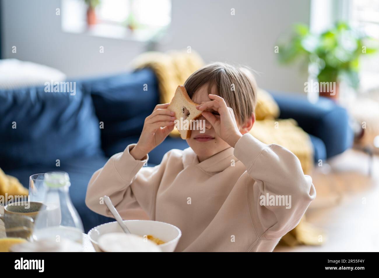 Boy child playing with slice of bread during breakfast Stock Photo - Alamy
