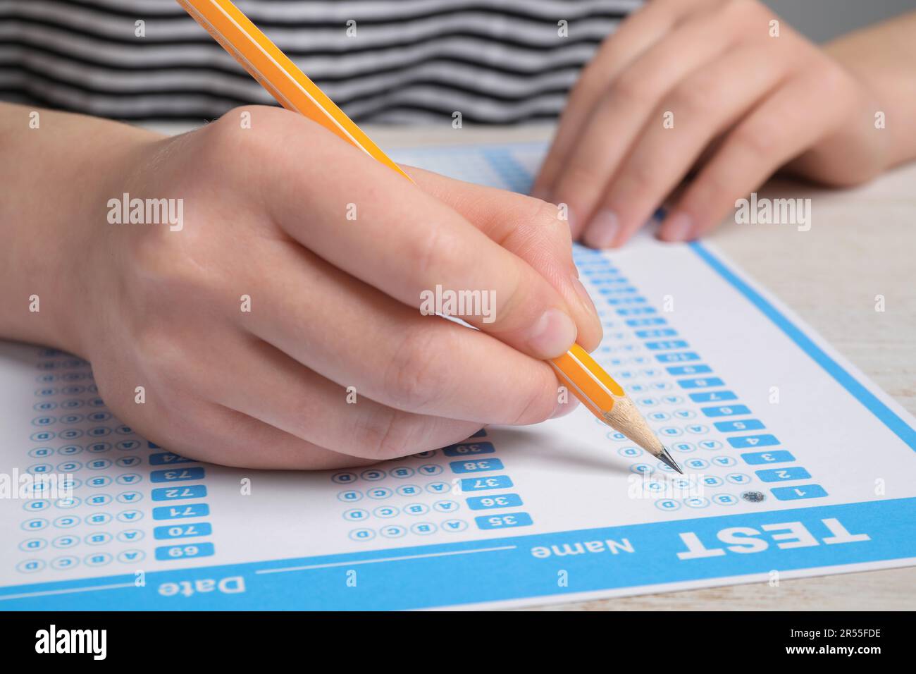 Student filling answer sheet at table, closeup. Passing exam Stock ...