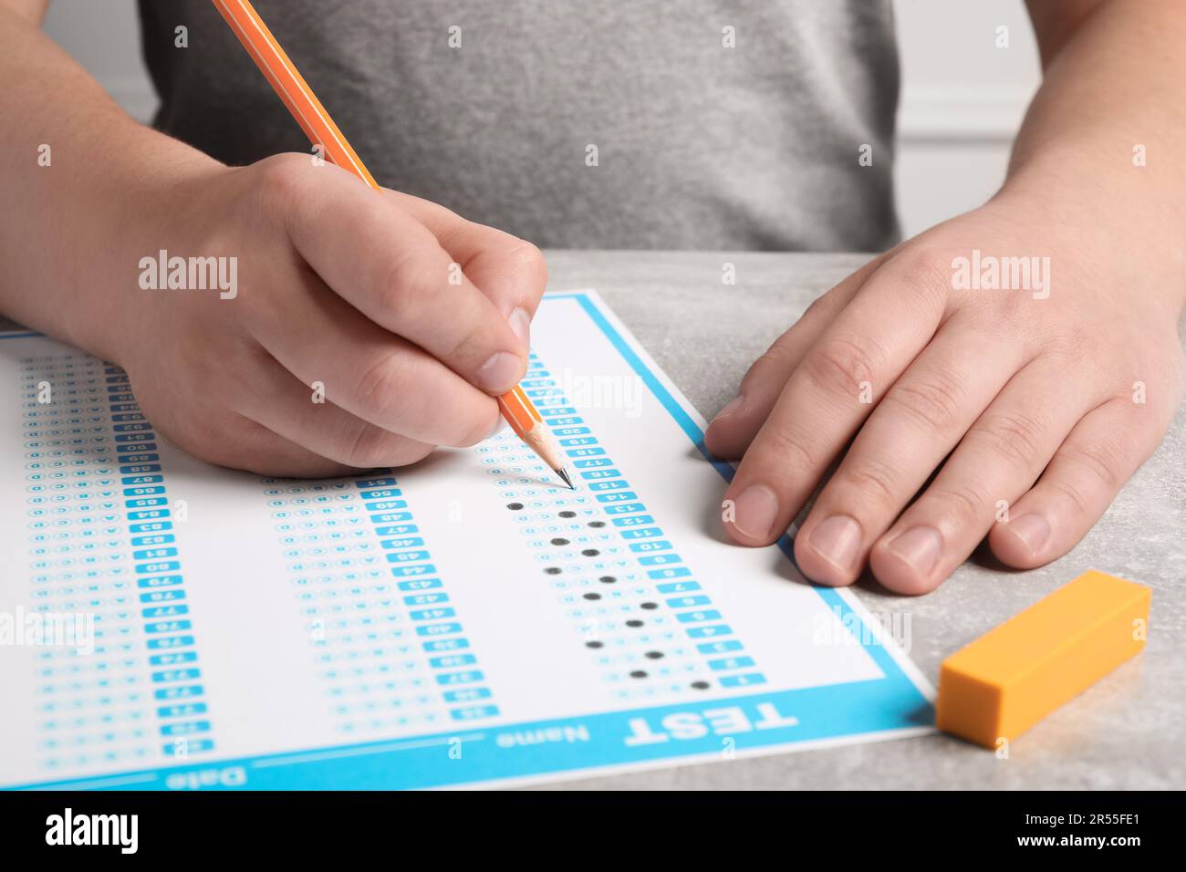 Student filling answer sheet at table, closeup. Passing exam Stock ...