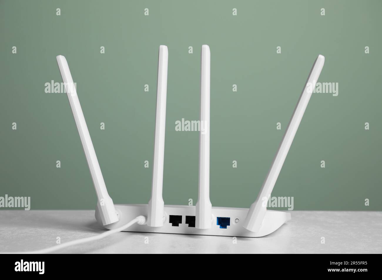 New modern Wi-Fi router on white table near green wall Stock Photo - Alamy