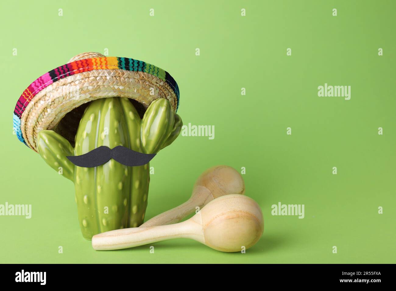 Wooden maracas, toy cactus with sombrero hat and mustache on light ...