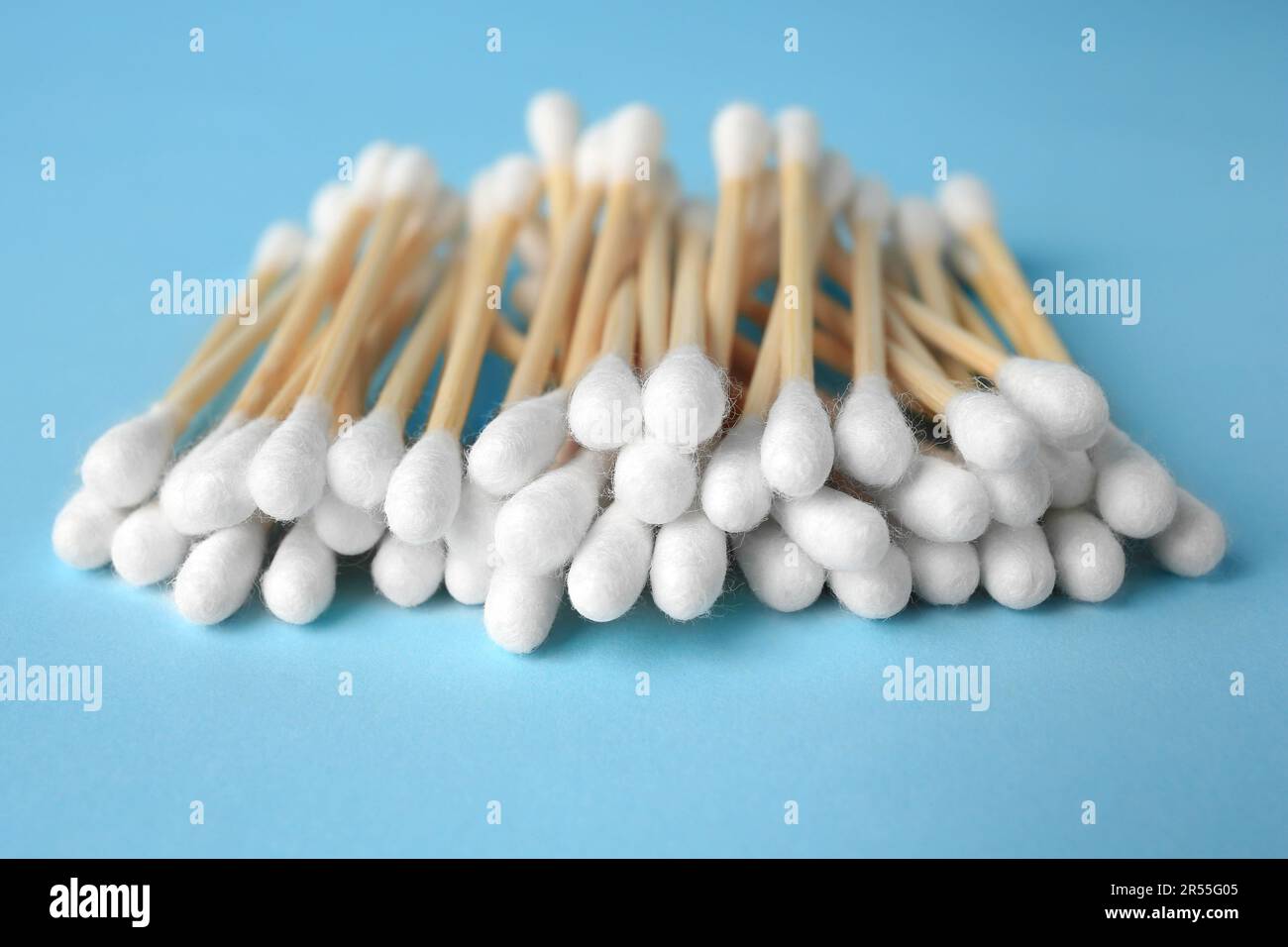 Heap of clean cotton buds on light blue background Stock Photo - Alamy