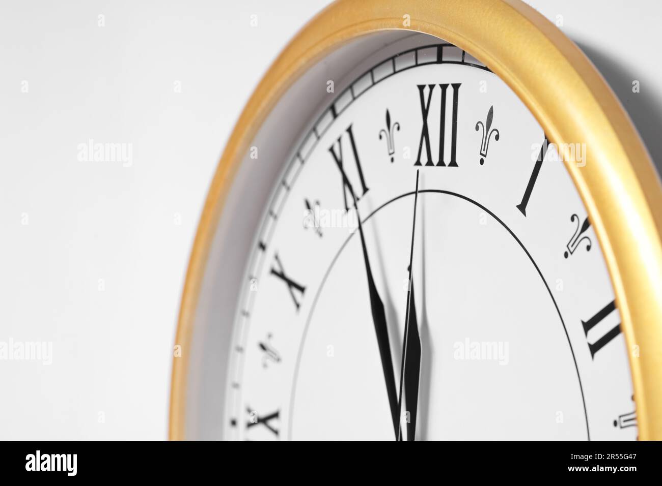 Clock showing five minutes until midnight on white background, closeup ...