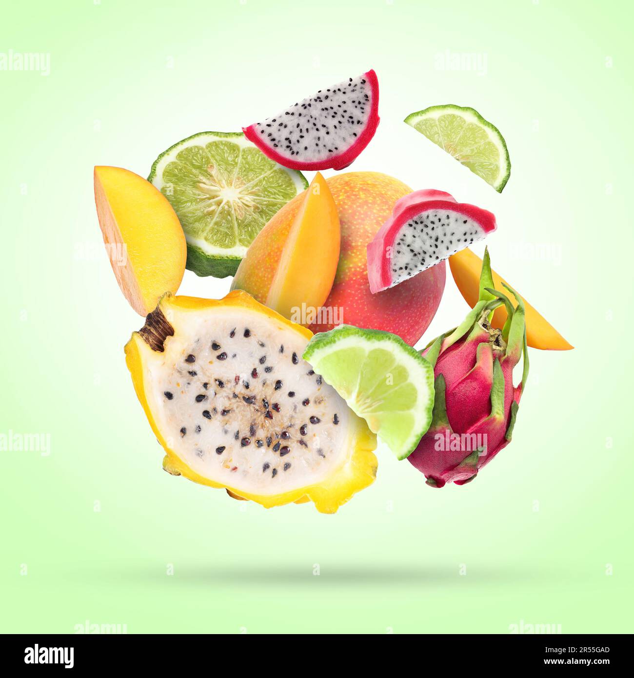 Many fresh tropical fruits falling on light green background Stock ...