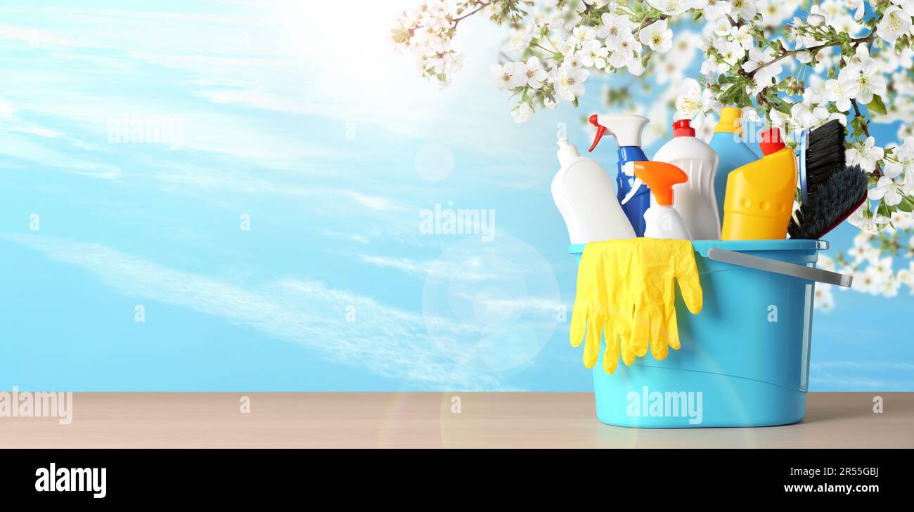 Spring cleaning. Bucket with detergents and tools on wooden surface ...