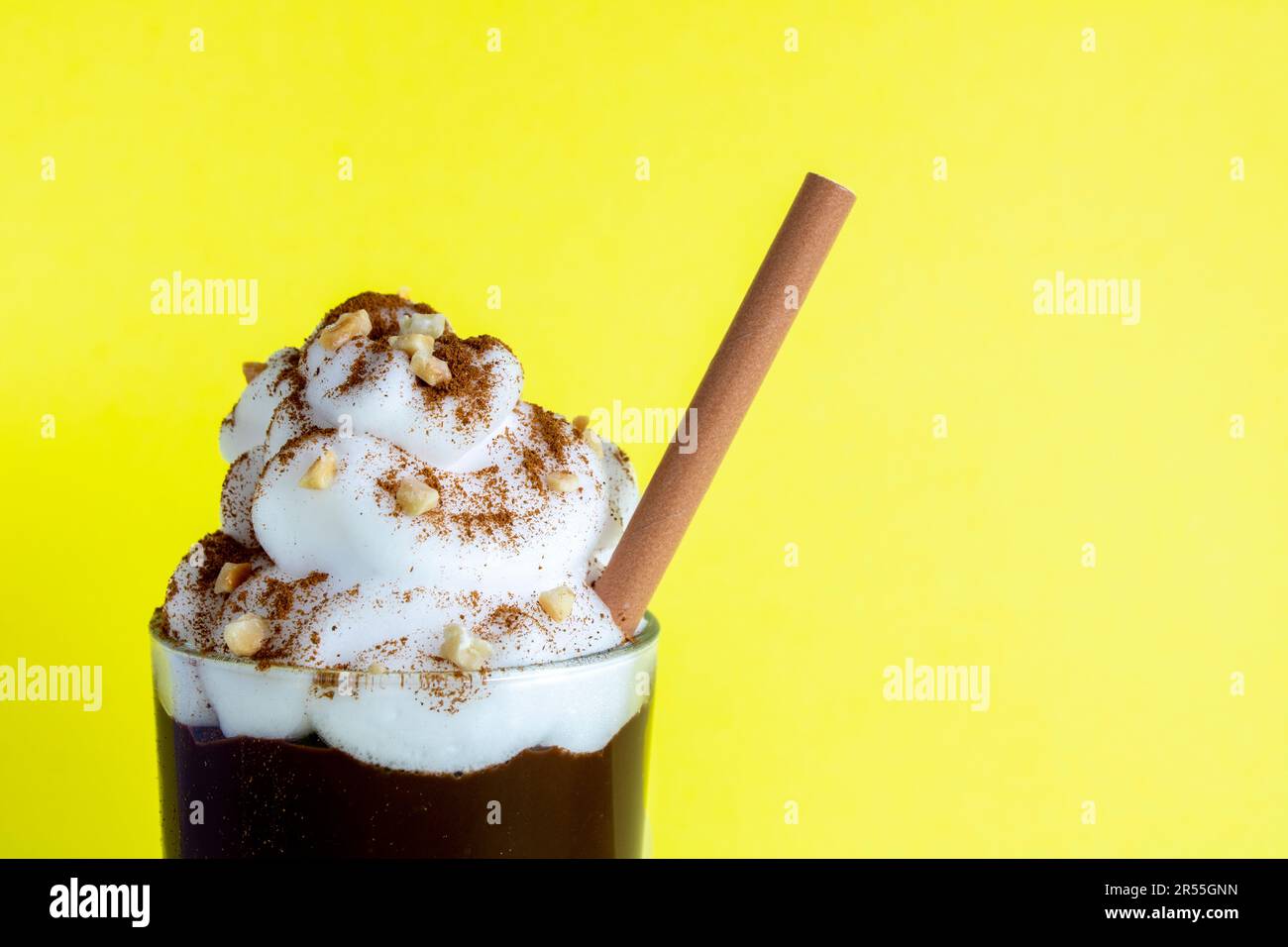 Close-up glass of chocolate milkshake with cream, toasted almonds and ...