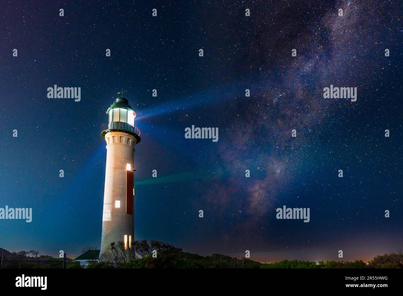 Night time scene of the Milky Way Galaxy over a coastal lighthouse at ...