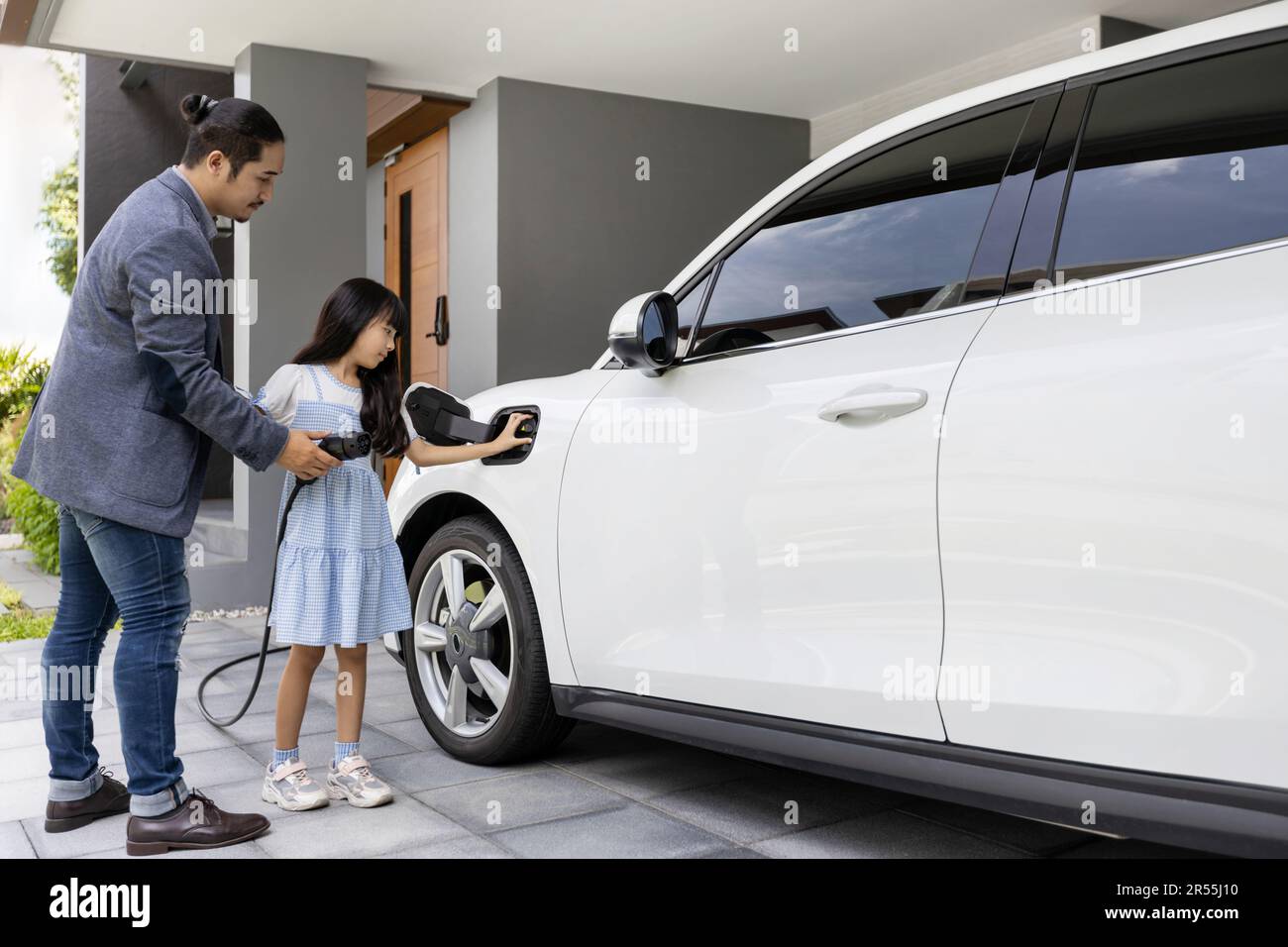 Progressive father and daughter plugs EV charger from home charging ...