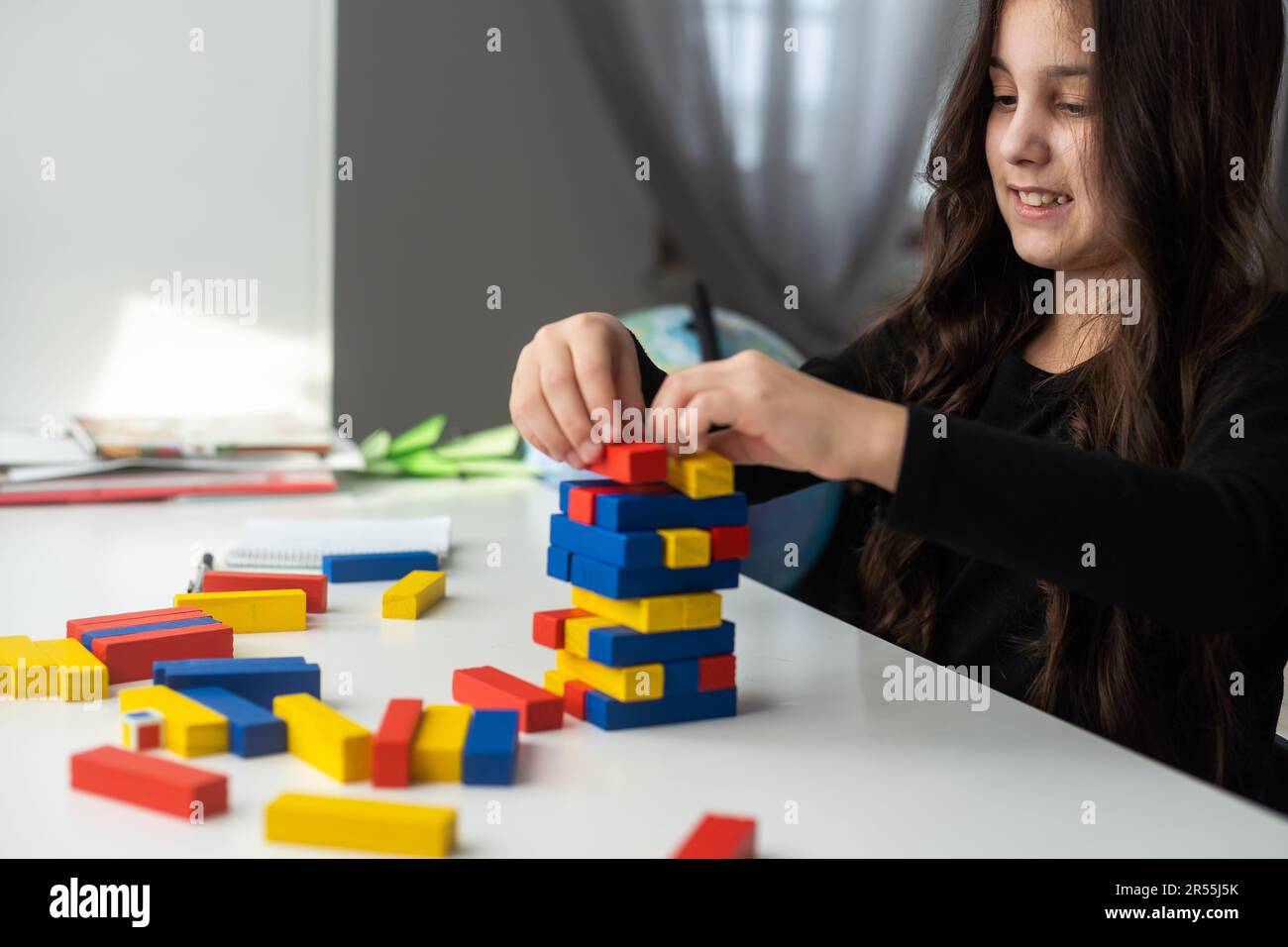 Cute little girl excites with wooden block game Stock Photo - Alamy