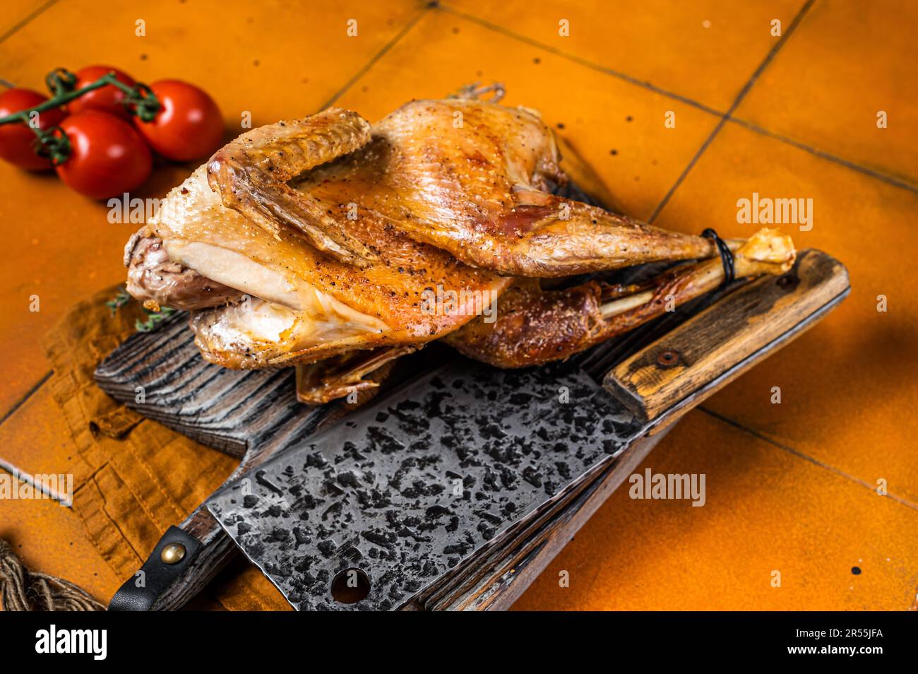 Grilled guinea fowl with herbs and spices on butcher board, cooked game ...