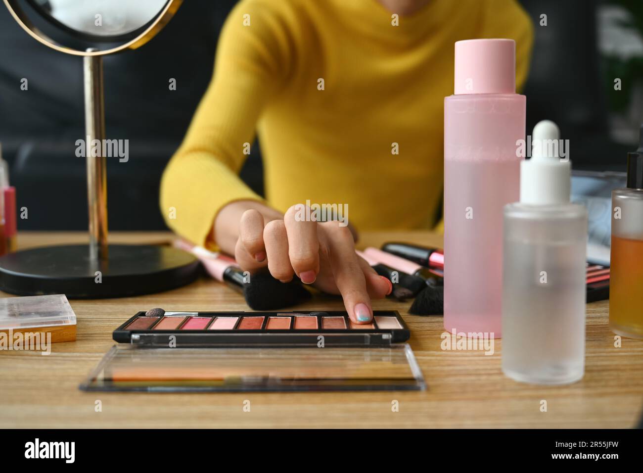 Closeup view of finger touching in eyeshadow palette. Beauty blogger ...