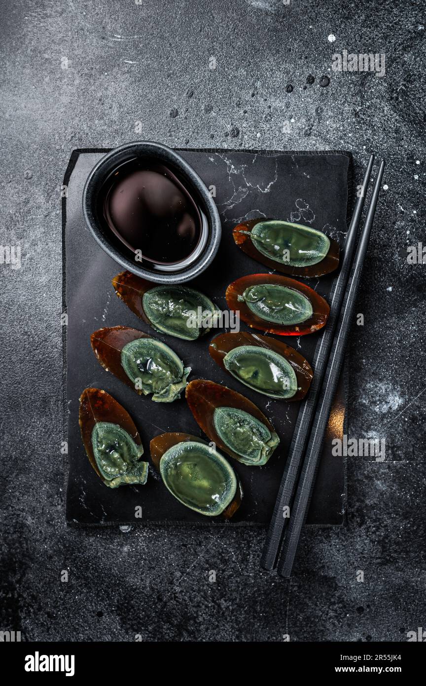 Chinese Century eggs, black egg is cut showing dark yolk. Black ...